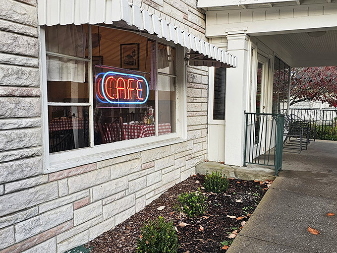 The neon "CAFE" sign glows like a beacon of culinary hope, promising Southern comfort behind those stone walls and checkered curtains.
