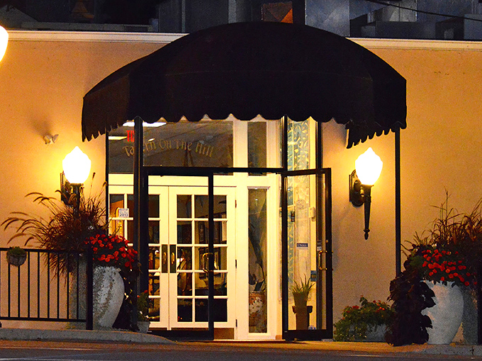 The entrance to Tavern on the Hill beckons with elegant simplicity, flanked by seasonal blooms and classic sconce lighting&mdash;like a culinary speakeasy hiding in plain sight.