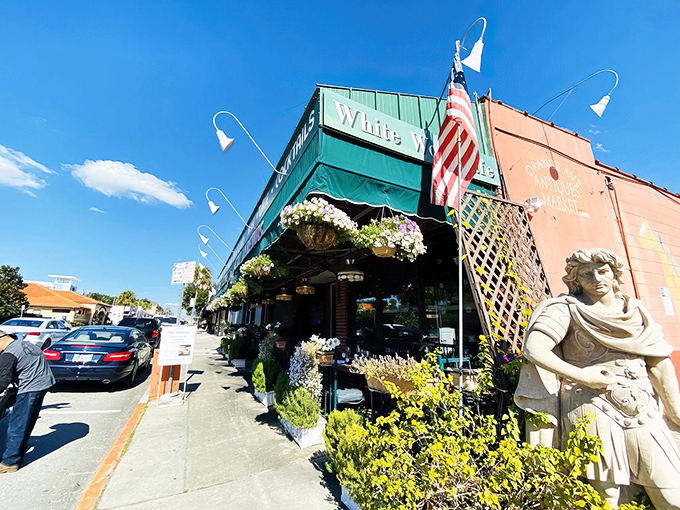 The distinctive green awning and coral exterior of White Wolf Cafe beckons like an oasis in Orlando's Ivanhoe Village, complete with a classical statue standing sentry.