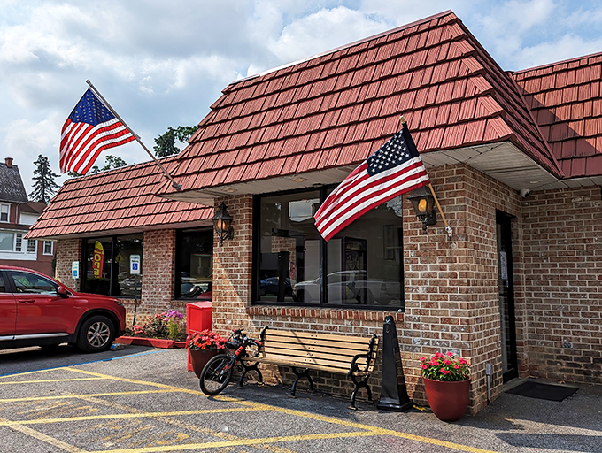 The classic red-tiled roof and American flags announce this culinary treasure like a delicious secret hiding in plain sight.