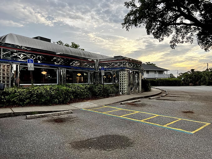 The chrome-clad exterior of Scenic 90 Cafe glows at dusk, a shining beacon of comfort food that promises nostalgic flavors inside those glass brick walls.