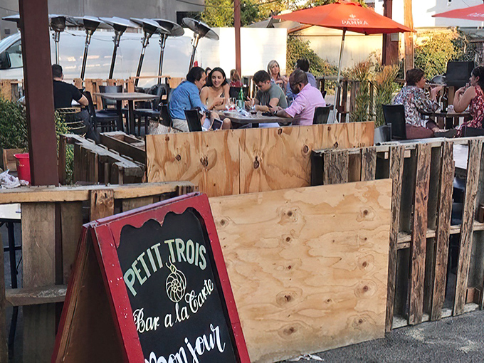 The sidewalk patio at Petit Trois offers a slice of Parisian café culture right on Highland Avenue. Red signage announces this culinary gem to those lucky enough to be in the know.