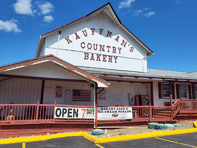 The iconic white barn facade of Kauffman's Country Bakery stands proudly against Ohio's blue sky, promising carb-laden treasures within.