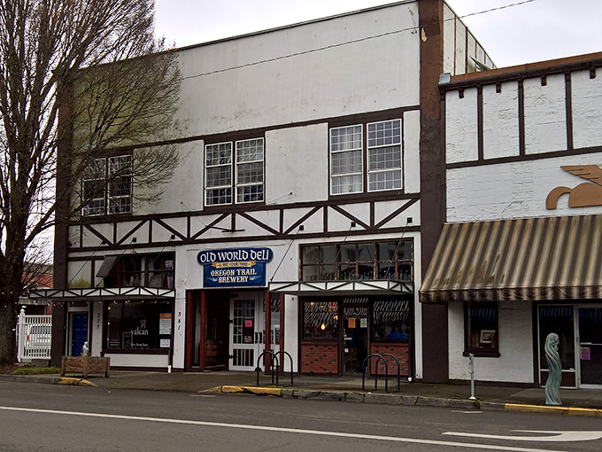 Tudor-style charm meets sandwich paradise at Old World Deli's distinctive exterior. The blue sign promises a delicious adventure waiting just beyond those wooden doors.