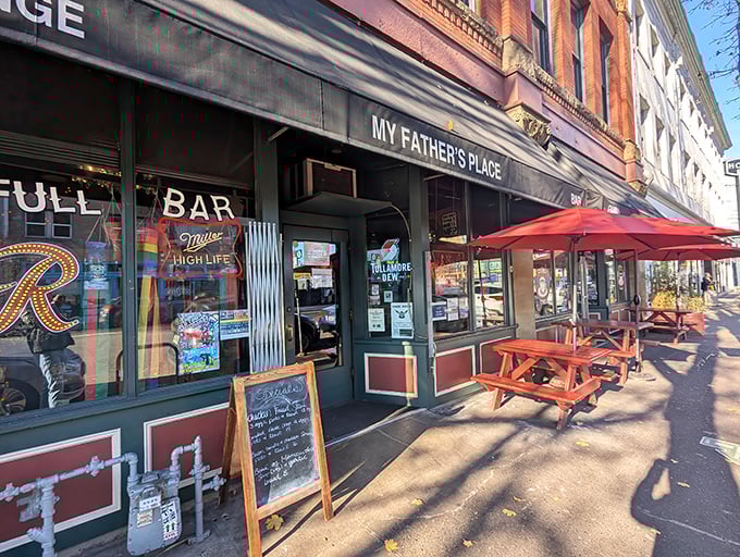 The unassuming storefront of My Father's Place beckons with its classic red picnic tables and vintage signage, promising comfort food without pretension.