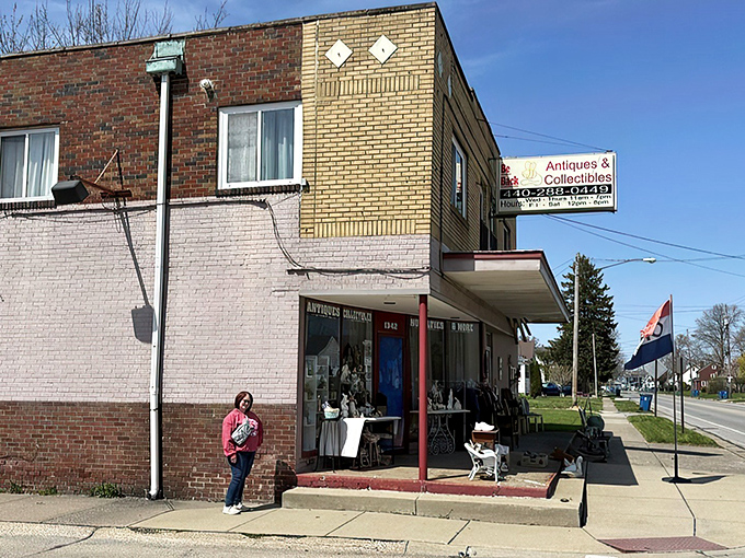 The blue door beckons like a portal to the past, with treasures spilling onto the sidewalk. White wicker furniture and vintage collectibles offer just a hint of what awaits inside.