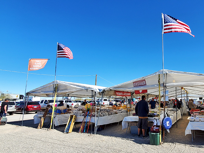 American flags flutter above white canopies at Arizona Market Place, where treasure hunting begins under the brilliant Yuma sky.