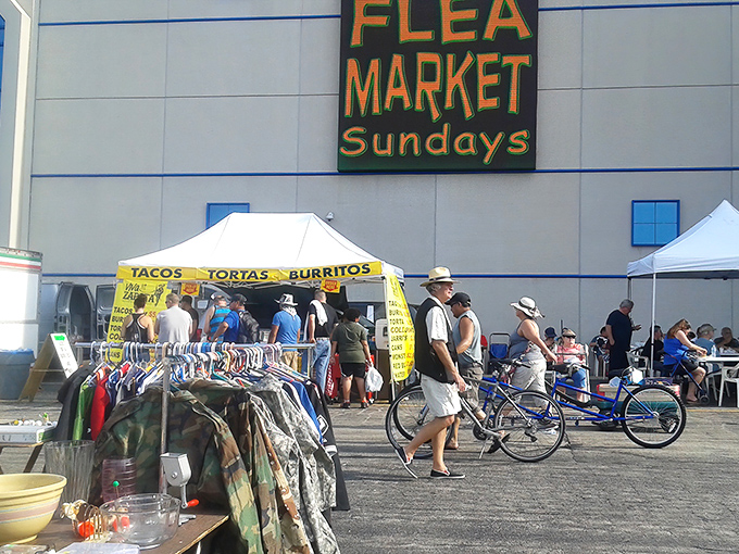 The iconic yellow "FLEA MARKET Sundays" sign beckons like a treasure map X marking the spot. Weekend adventures await beneath.