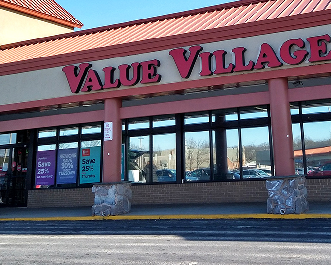 The iconic red Value Village sign beckons like a lighthouse for bargain hunters, promising treasures within those sliding glass doors.