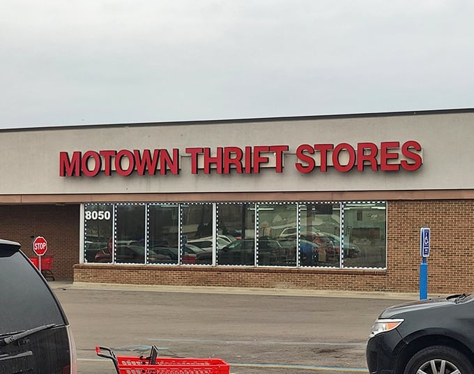 The iconic red Motown Thrift sign beckons bargain hunters like a retail lighthouse, promising treasures within this unassuming Westland storefront.