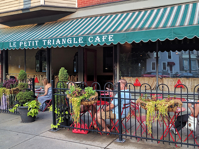 The charming brick facade of Le Petit Triangle Cafe beckons with its distinctive yellow awning and wrought-iron fence&mdash;a little slice of Paris on a Cleveland corner.