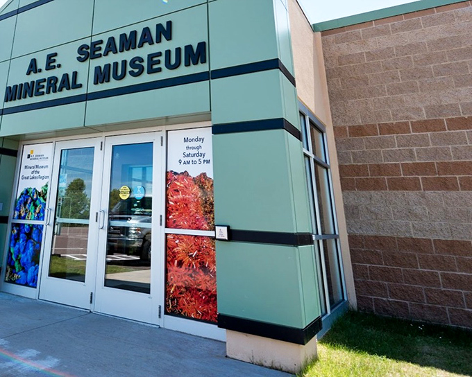 The modern exterior of the A.E. Seaman Mineral Museum beckons with colorful mineral images that hint at the geological wonders waiting inside.