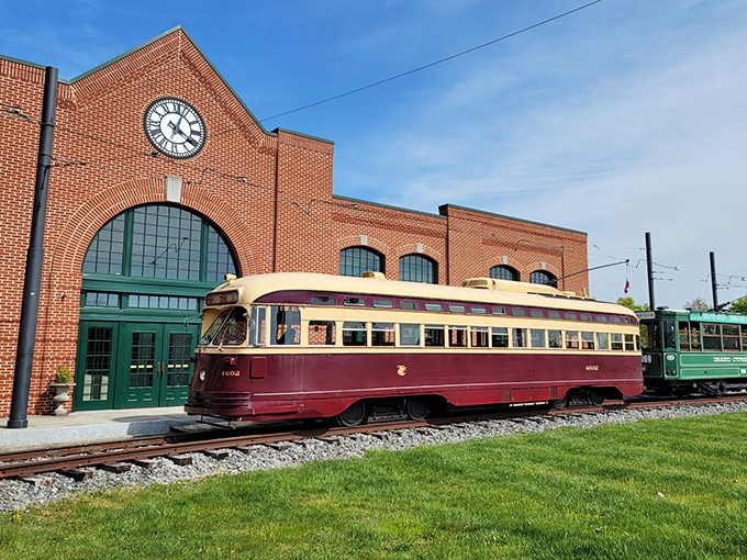 The brick facade of the National Capital Trolley Museum stands proudly against a blue sky, with a beautifully restored burgundy and cream trolley ready to transport visitors to simpler times.