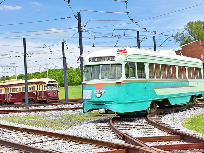 The brick facade of the National Capital Trolley Museum stands proudly against a blue sky, with a beautifully restored burgundy and cream trolley ready to transport visitors to simpler times.