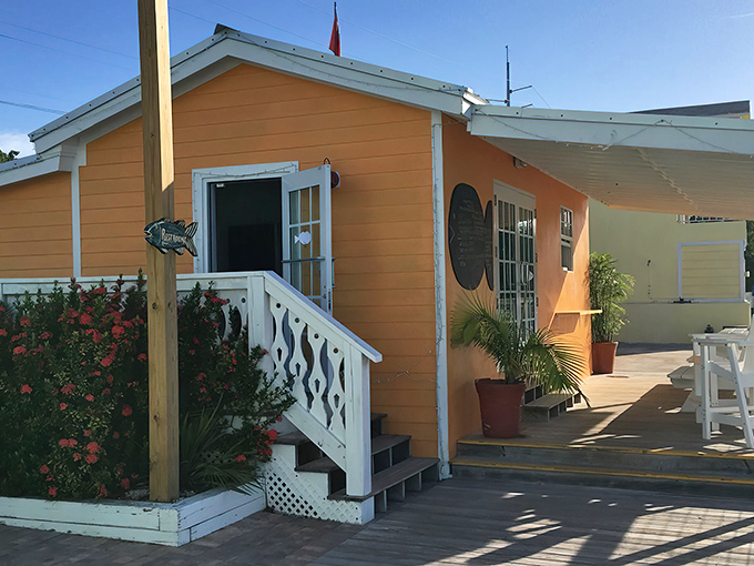 The cheerful orange exterior of What The Fish? beckons like a tropical sunset, promising seafood treasures behind those white-trimmed doors.