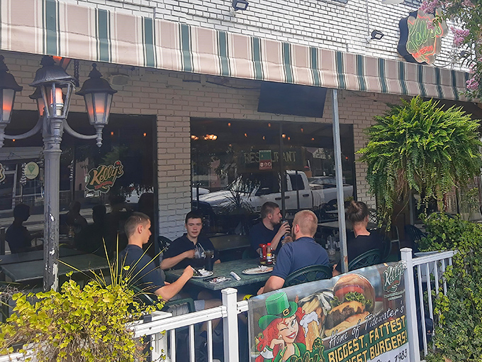 Kelly's welcoming exterior beckons with its classic striped awning and lush greenery. The patio seating offers a perfect perch for people-watching while savoring their famous fare.