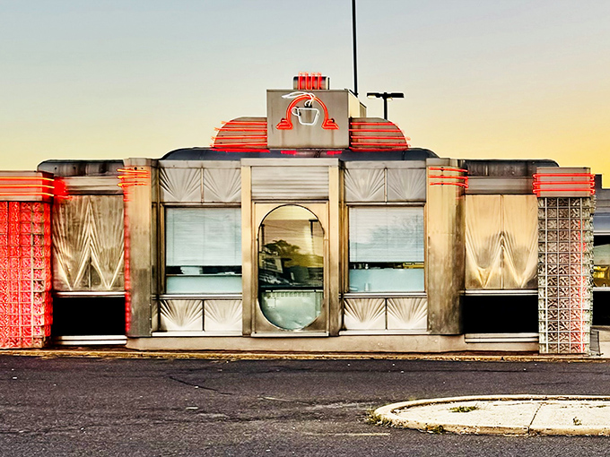 The neon-trimmed exterior of The Dining Car glows like a time machine to the golden age of American diners, beckoning hungry travelers day and night.