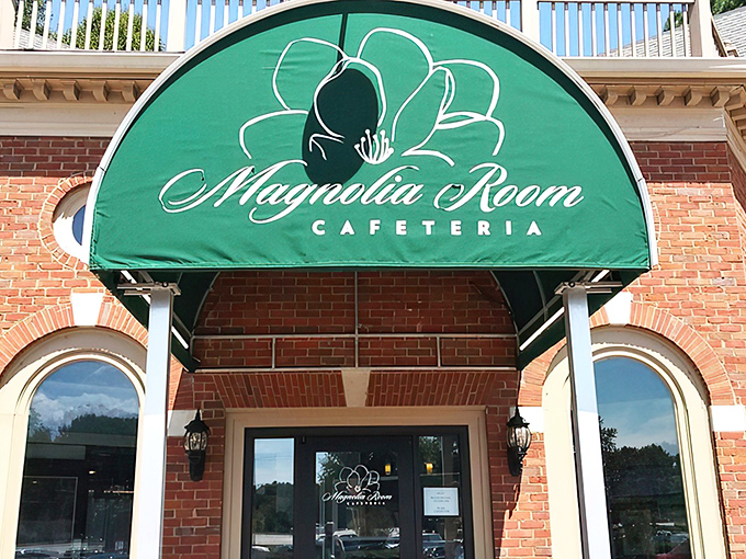 The brick exterior of Magnolia Room Cafeteria welcomes diners with Southern charm, complete with teal benches and colorful flower arrangements that practically whisper "come on in, y'all."