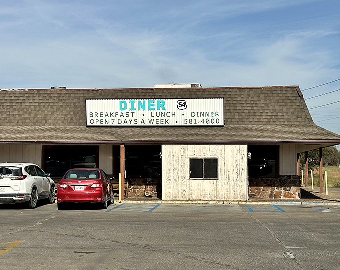 The classic roadside sign beckons hungry travelers like a lighthouse for the famished. Diner 54's unassuming exterior promises honest food without pretension.