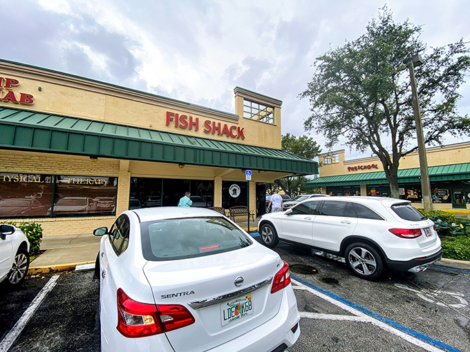 The unassuming yellow storefront with bold red "FISH SHACK" lettering promises what fancy restaurants often can't deliver: seafood that makes you forget your table manners.