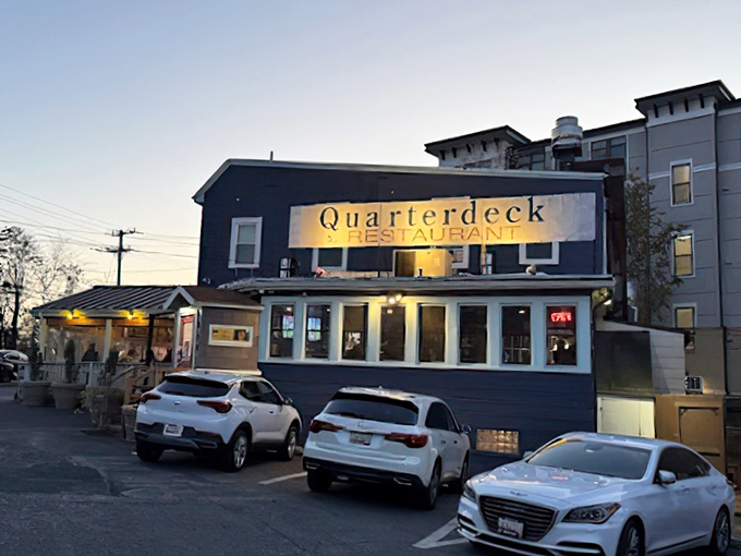 The navy blue exterior of Quarterdeck glows at dusk, a beacon for crab lovers hiding in plain sight along Arlington's streets.