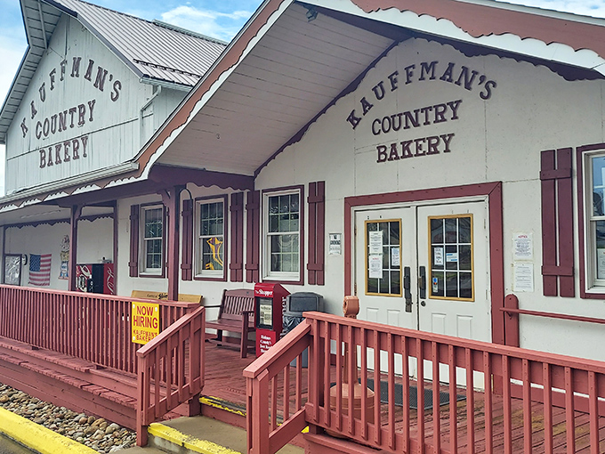 The iconic white barn facade of Kauffman's Country Bakery stands proudly against Ohio's blue sky, promising carb-laden treasures within.