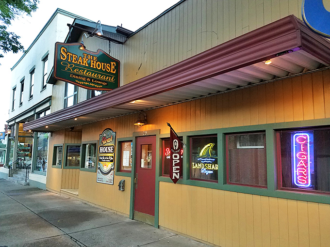 The yellow clapboard exterior of The Steak House in Wellsboro beckons like a beacon of hope for hungry travelers, complete with charming sidewalk seating.