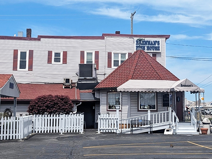 The unassuming exterior of Brennan's Fish House stands like a maritime sentinel in Grand River, complete with its iconic red-roofed turret and welcoming porch.