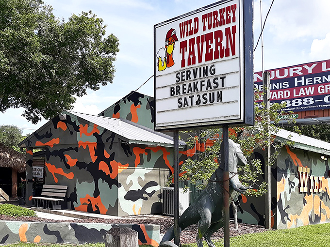 The unmistakable Wild Turkey Tavern exterior, where camouflage paint and a life-sized turkey statue announce you've found Florida's burger paradise.