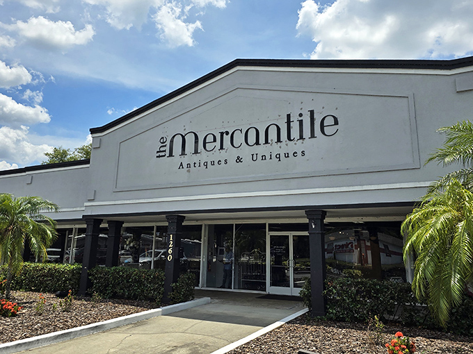 The white facade gleams like a treasure chest in the Florida sun, palm trees standing guard at the entrance to vintage paradise.
