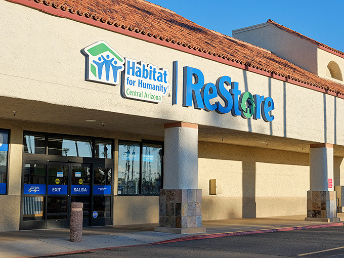 The desert sun gleams off the ReStore's distinctive blue and green signage, promising treasure hunters a climate-controlled oasis of bargains inside.