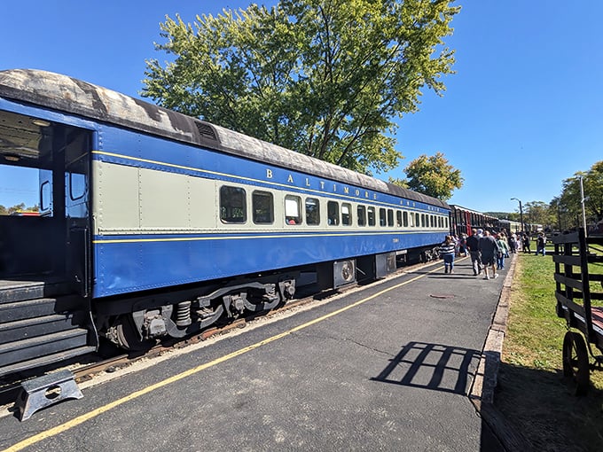 The vintage blue-and-gray "Baltimore" railcar waits at the platform under clear Ohio skies, ready to transport passengers on a nostalgic journey through time. 
