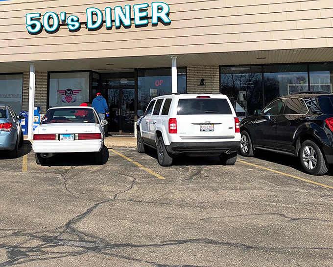 The blue neon sign of 50's Diner glows like a beacon for hungry travelers, promising a journey back to simpler times when calories didn't count and breakfast reigned supreme.