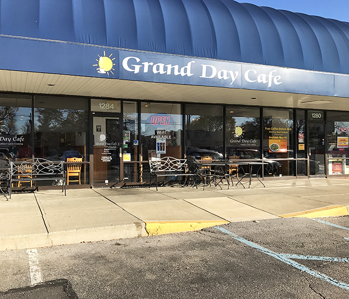 The blue awning of Grand Day Cafe beckons like a breakfast lighthouse, guiding hungry souls to a harbor of hash brown perfection.