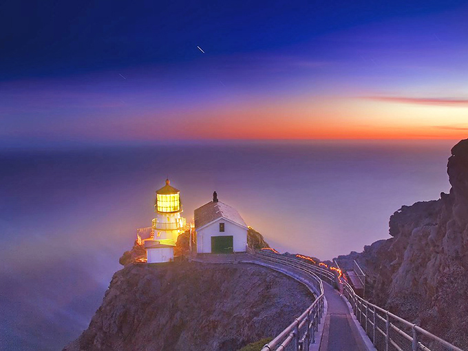 Twilight magic transforms Point Reyes Lighthouse into a beacon of dreams, where purple skies meet golden light in California's most dramatic sunset show.