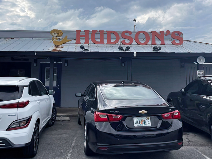 The iconic red Hudson's sign welcomes hungry seafood pilgrims like a maritime lighthouse guiding ships to delicious shores.