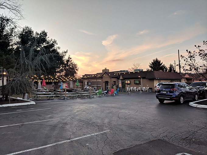 Sunset creates magic over The Fainting Goat's inviting exterior. String lights twinkle with promise while picnic tables await diners seeking that perfect Pennsylvania evening vibe.