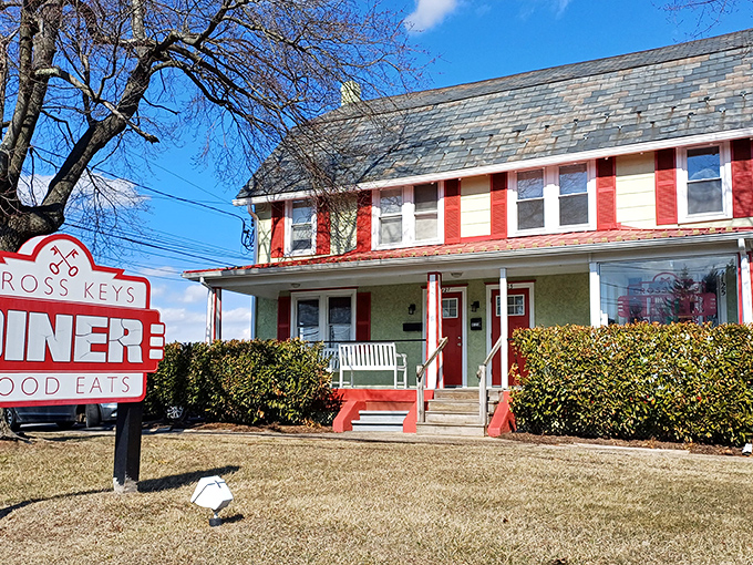 The red and white farmhouse exterior of Cross Keys Diner stands like a beacon of breakfast hope in Doylestown, promising "Good Eats" to all who enter.