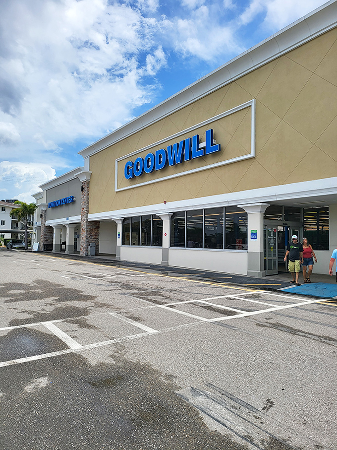 The blue Goodwill sign beckons like a treasure map X-marking-the-spot, promising adventures in secondhand shopping under Florida's ever-present azure skies.