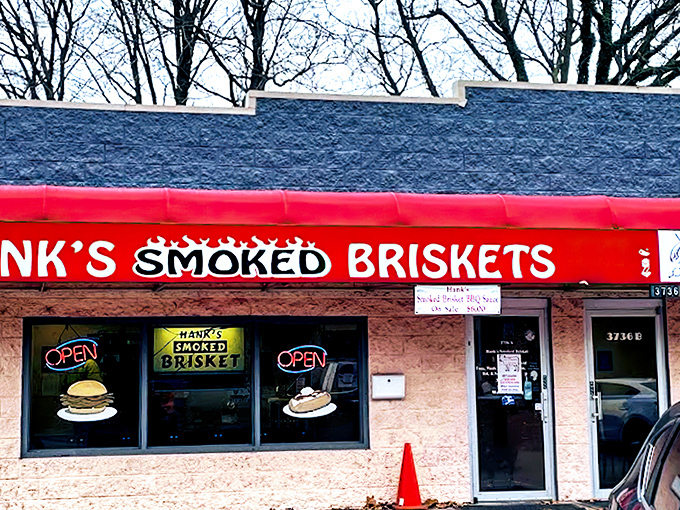 The bright red awning of Hank's stands out like a beacon for barbecue pilgrims, promising smoky salvation inside this unassuming Indianapolis treasure.