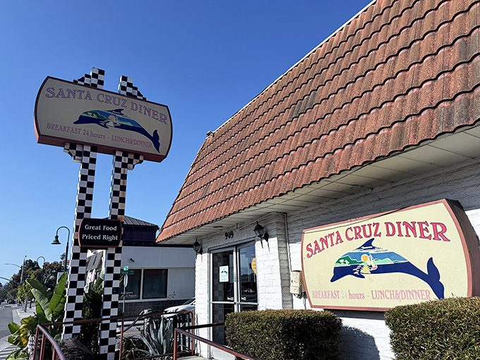 The iconic checkerboard sign welcomes hungry travelers like a coastal lighthouse for the famished. Classic California diner architecture with a surfer's twist.
