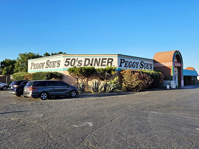 Like a rainbow-colored mirage in the desert, Peggy Sue's 50's Diner stands proudly against the Mojave sky, promising nostalgic delights to weary travelers.