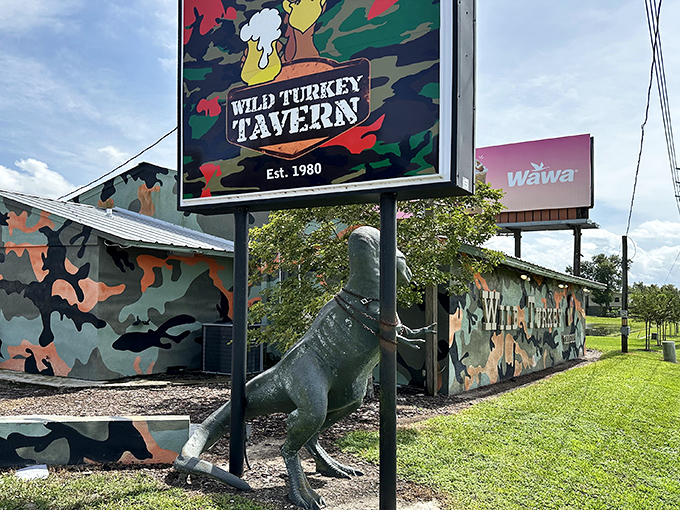 The unmistakable Wild Turkey Tavern exterior, where camouflage paint and a life-sized turkey statue announce you've found Florida's burger paradise.