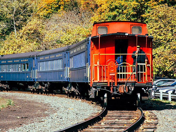 The iconic red caboose and blue coaches of the Lehigh Gorge Scenic Railway wind through autumn's paintbox&mdash;nature's own masterpiece on full display.