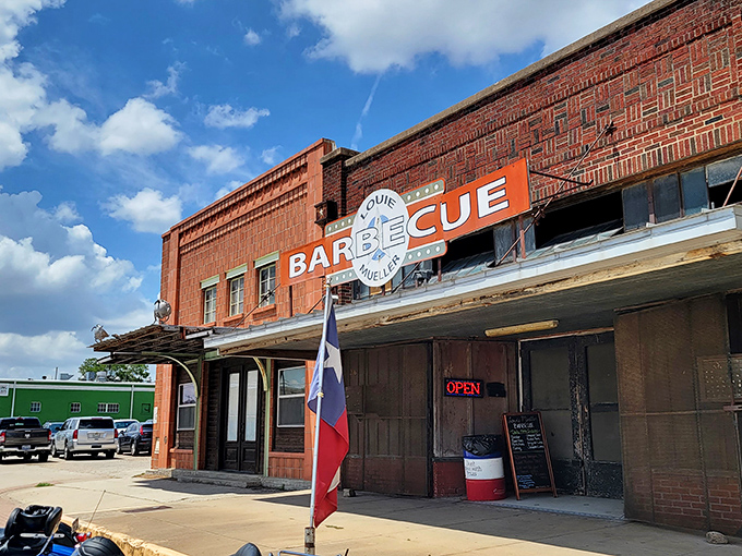 The iconic brick exterior of Louie Mueller Barbecue stands as a beacon of hope for hungry travelers. Texas barbecue pilgrims have been making this journey for generations.