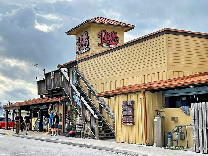 Rusty's sunny yellow exterior stands like a beacon for seafood lovers, with its weathered wooden deck promising waterfront views and maritime memories.