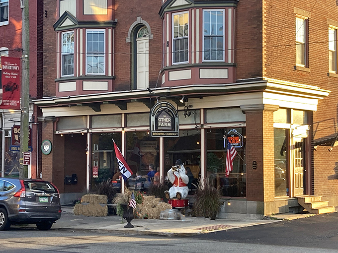 The charming storefront of The Other Farm beckons with its classic Pennsylvania brick facade, wooden bench, and barrel planters&mdash;small-town Americana at its most inviting.