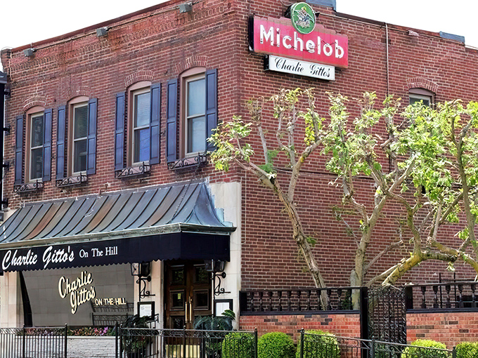 The classic brick exterior of Charlie Gitto's, with its vintage Michelob sign, stands as a beacon of Italian culinary tradition in St. Louis' historic Hill neighborhood.