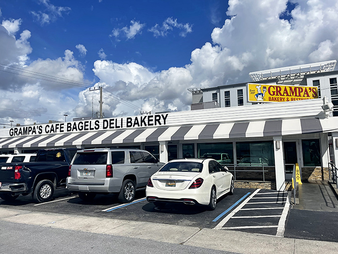 The classic black-and-white striped awning isn't just retro charm&mdash;it's a beacon for bagel lovers across South Florida. Grampa's exterior promises New York authenticity under swaying palm trees.