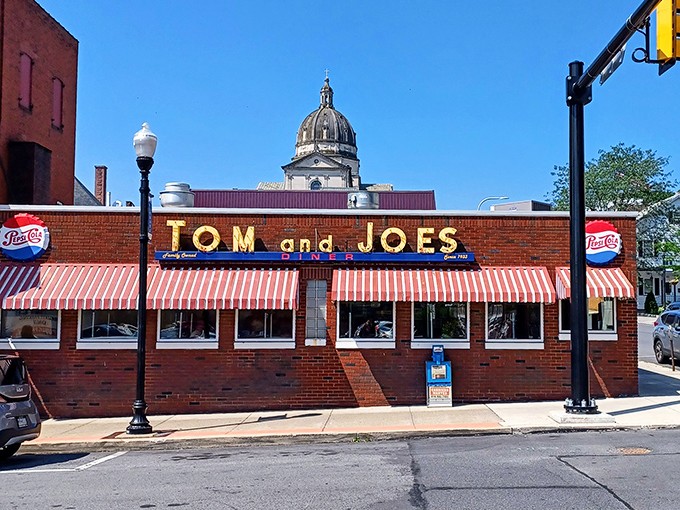 The iconic red-and-white awnings of Tom & Joe's stand proudly against Altoona's skyline, with the courthouse dome creating a perfect backdrop for this beloved diner.